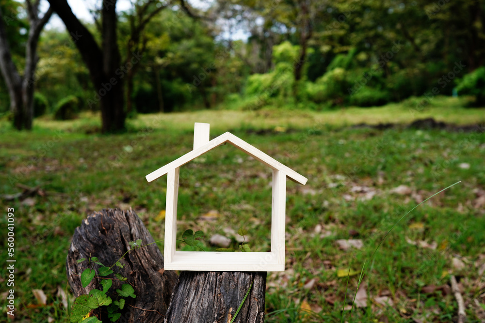Model of a wooden house on a stump outdoor The concept of cutting trees ...