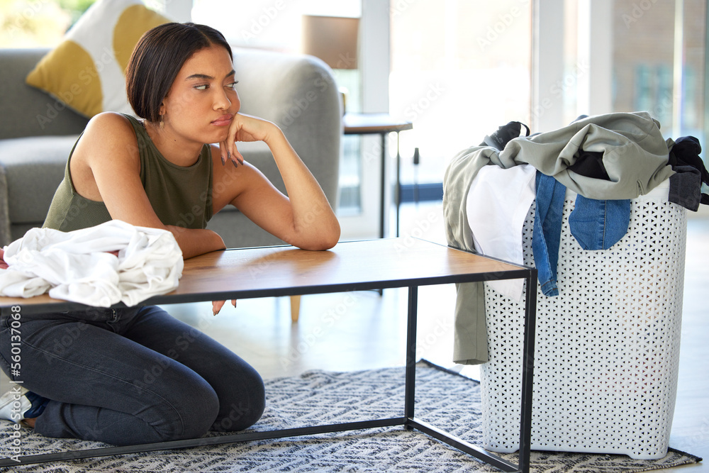 Bored, sad and woman cleaning laundry, housework stress and tired of ...