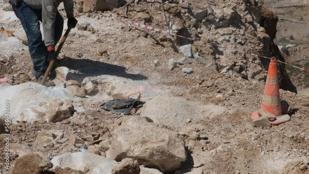 Holes drilled for quarry blast. Placing explosives in holes. The worker ...
