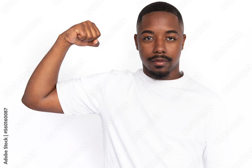 Confident young man showing his arm muscle. Male African American model ...