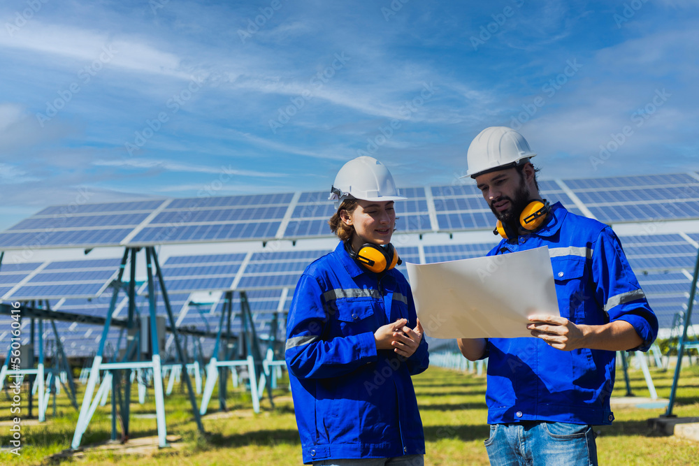 Engineers checking solar panel male and female worker wearing a uniform ...