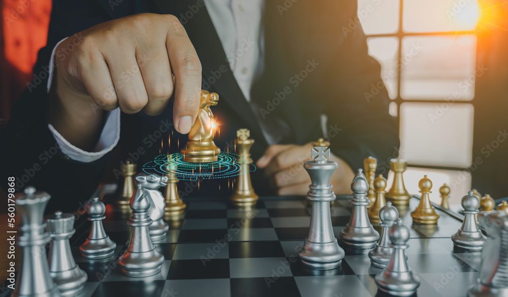 Hand of businessman holding gold knight chess on stock market or forex ...