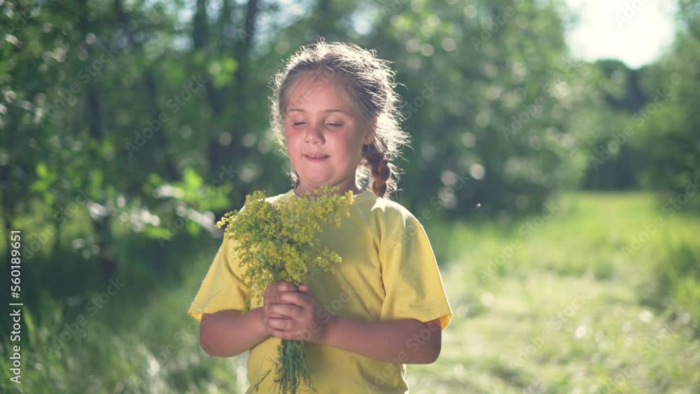 Happy child in field with flowers. Sunset in field with green grass ...
