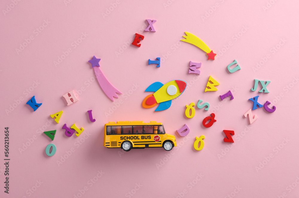 Toy school bus with a rocket and letters on pink background. Back to ...