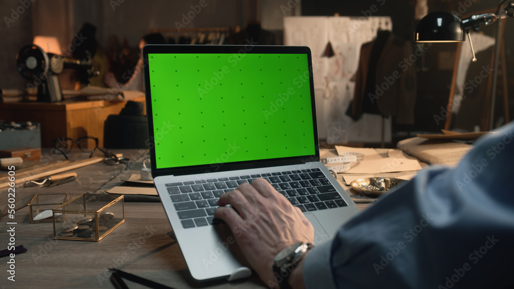 Male tailor or fashion designer creates and developes clothes on laptop ...