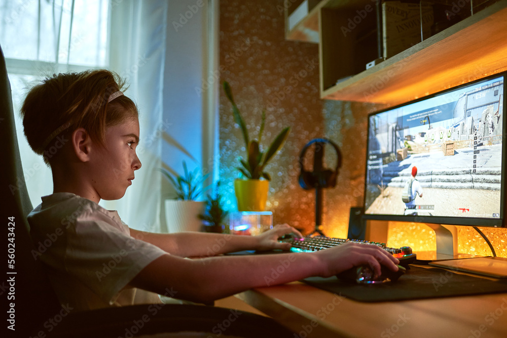 Image of immersed teenage gamer boy playing video games on computer in ...