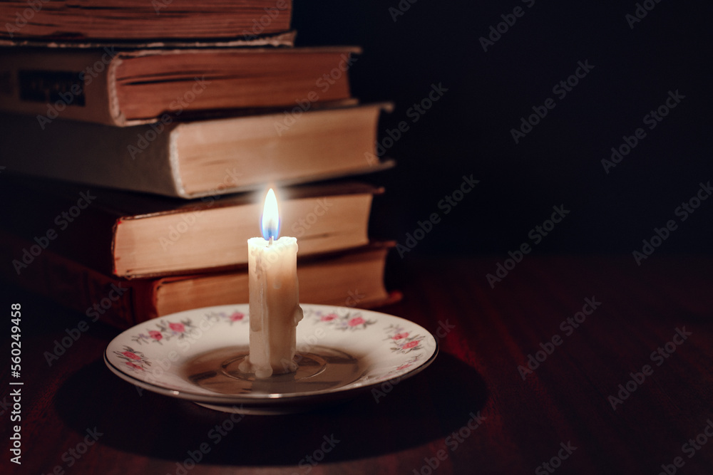 Learning by candlelight, reading in a dark room lit only by candles. In the village without ...