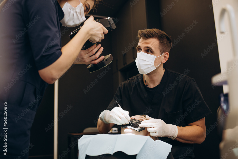 Dentist at work, dental clinic. Young woman doctor taking pictures of ...