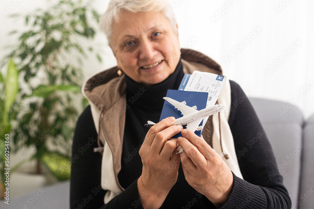 old woman holding Passport, boarding pass and toy airplane Stock Photo ...