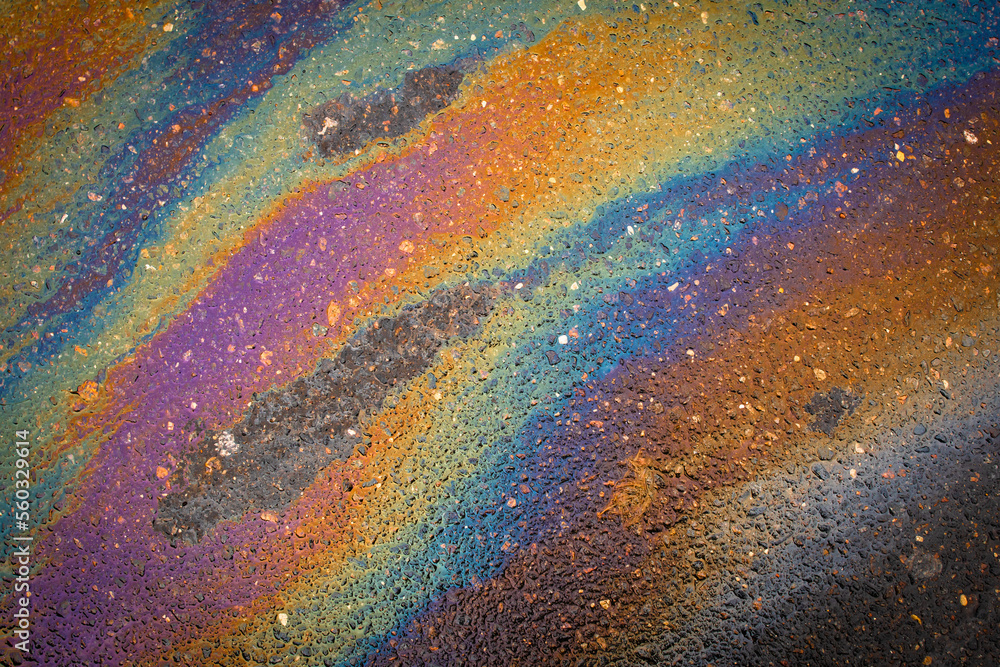 Oil stains from leaks in the car engine. Oil after rain makes spots ...