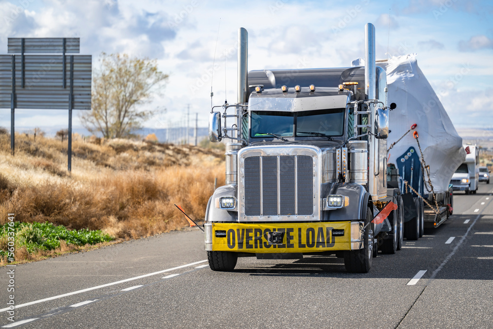 Classic American big rig black semi truck with oversize load sign ...