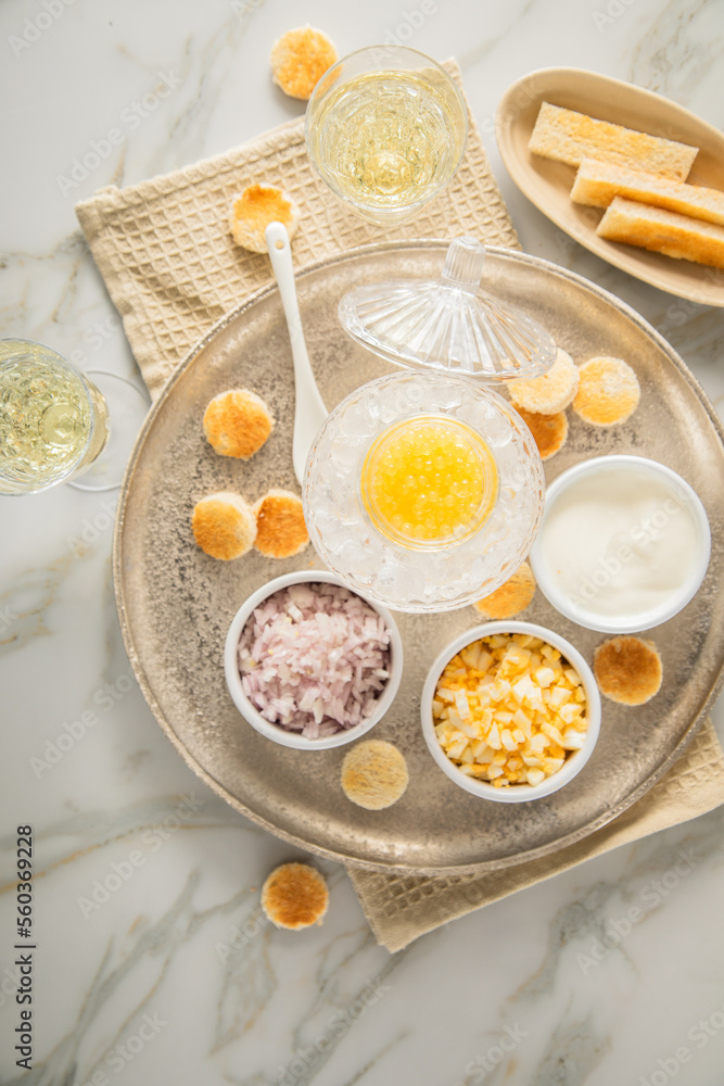 Gelber Saiblings Kaviar auf Eis in Glas Schale mit Porzellan Löffel ...