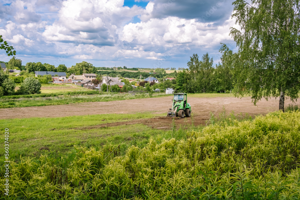 A green mini skid steer loader clear the construction site. Land work ...