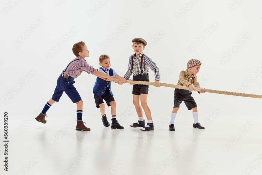 Sportive game. Group of little boys, children playing together, pulling ...