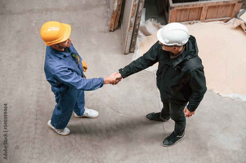 Two industrial workers are doing handshake. Top view. Successful ...