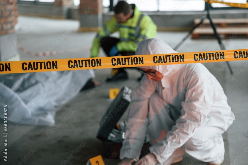 Caution police tape. Detectives are collecting evidence in a crime ...