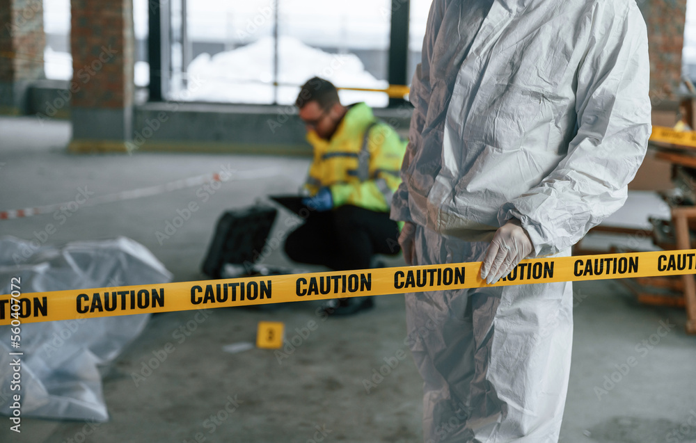 Holding caution police tape. Detectives are collecting evidence in a ...