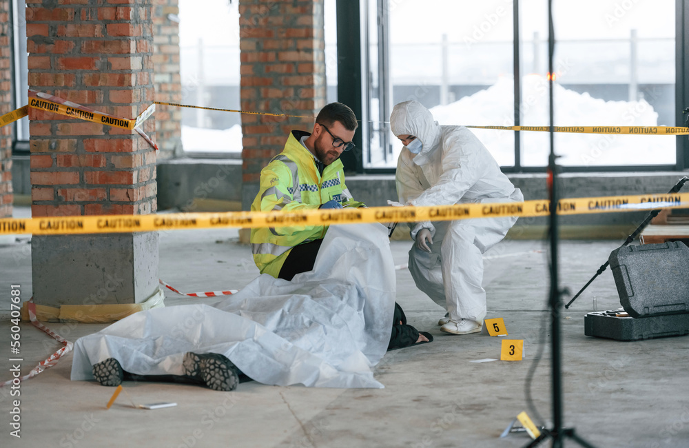 At daytime. Detectives are collecting evidence in a crime scene near ...