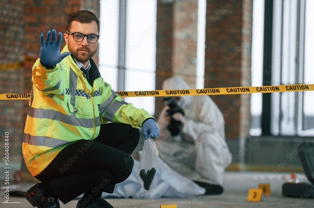 Dead body is on the ground. Detectives are collecting evidence in a ...