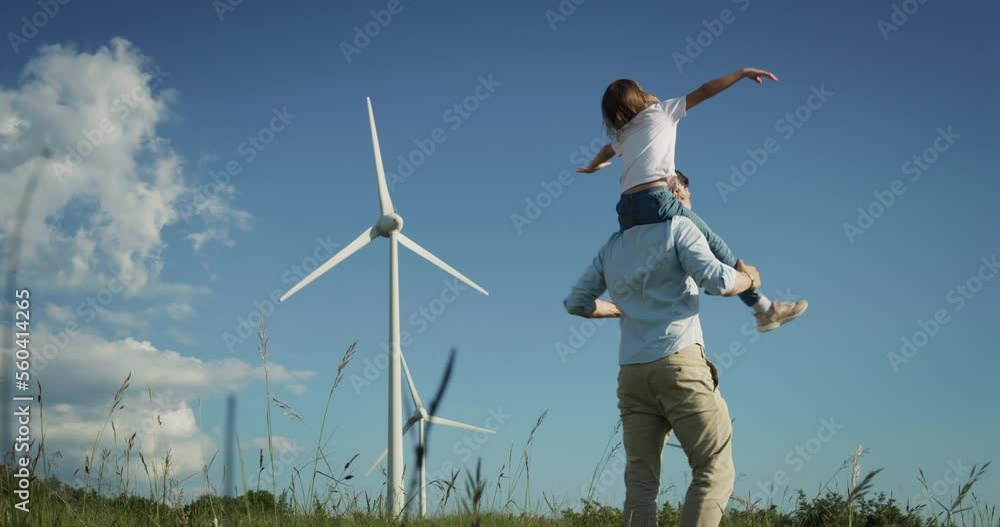 Father Lifting His Daughter on His Shoulders in a Wind Farm and Playing ...