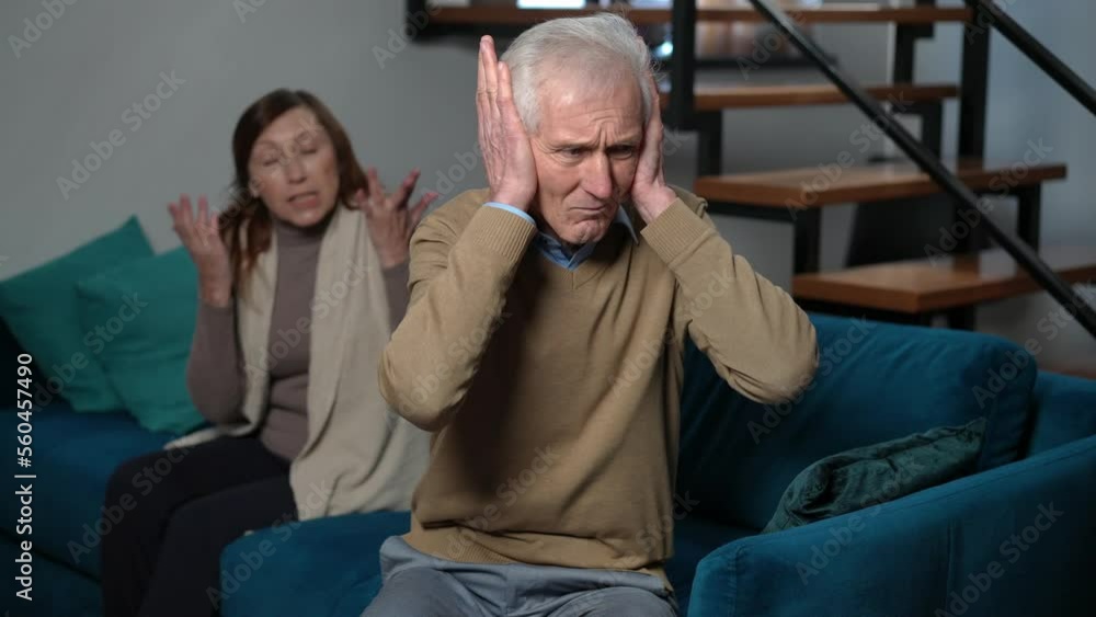 Sad Caucasian senior man covering ears with hands as angry woman ...