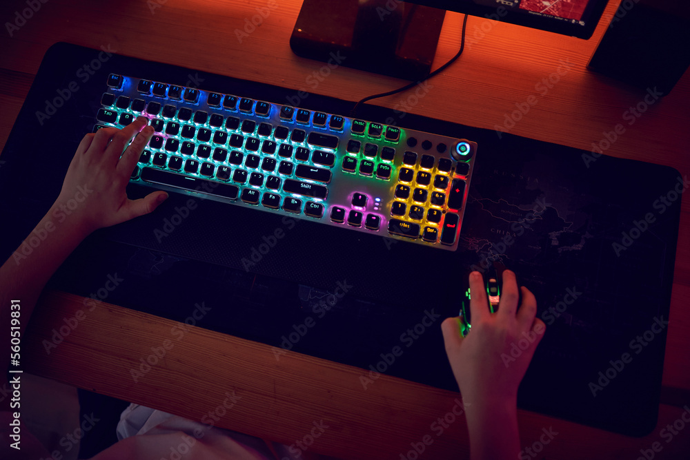 Hands of gamer man playing video games on computer in dark room using ...