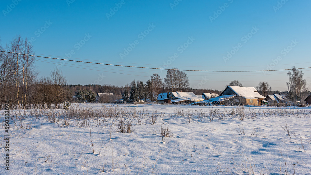 Rural landscape with village huts covered with white snow in winter ...