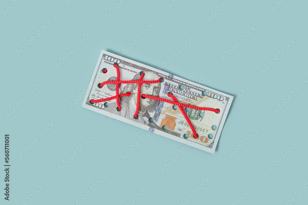 Hundred dollar bill stitched with red threads. Stock Photo | Adobe Stock