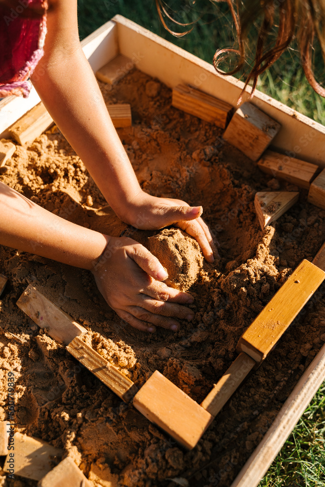 Crop child forming sand pyramid at sensory box Stock Photo | Adobe Stock