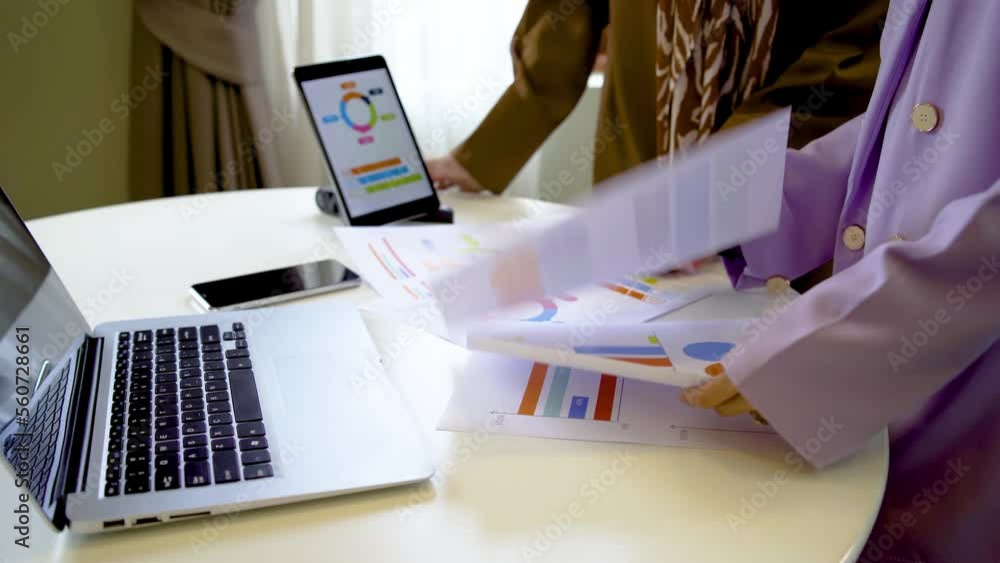 Two muslim business woman accountant pointing paper showing graphic ...