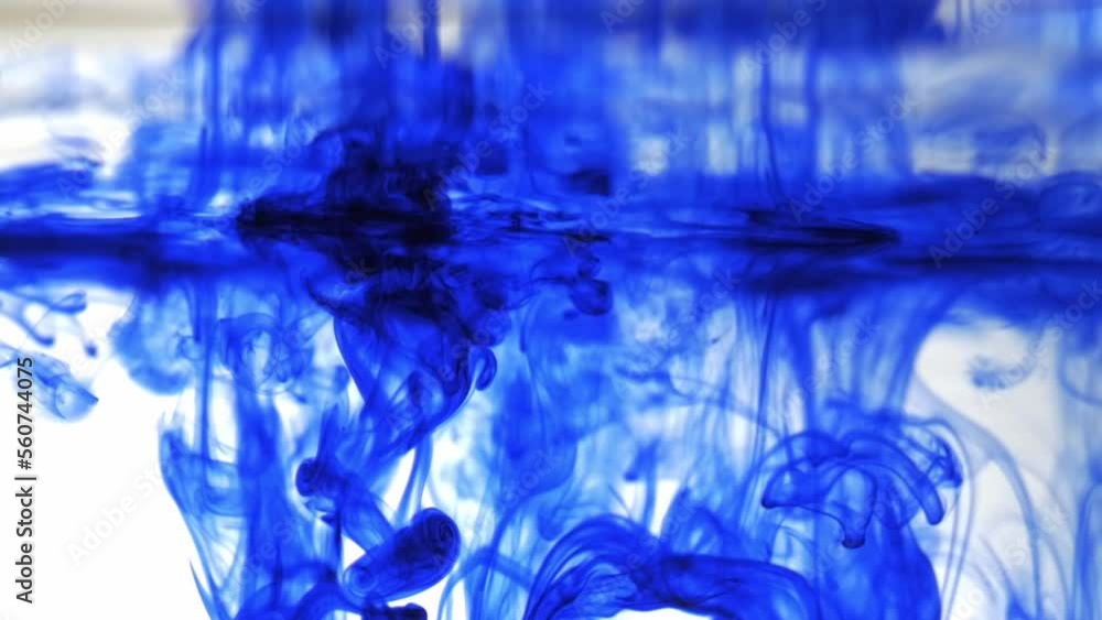 Slow blue ink on a white background, spills of colored paint on a ...