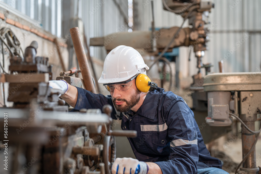 Male engineer wearing hearing protectors, protective goggles, and ...