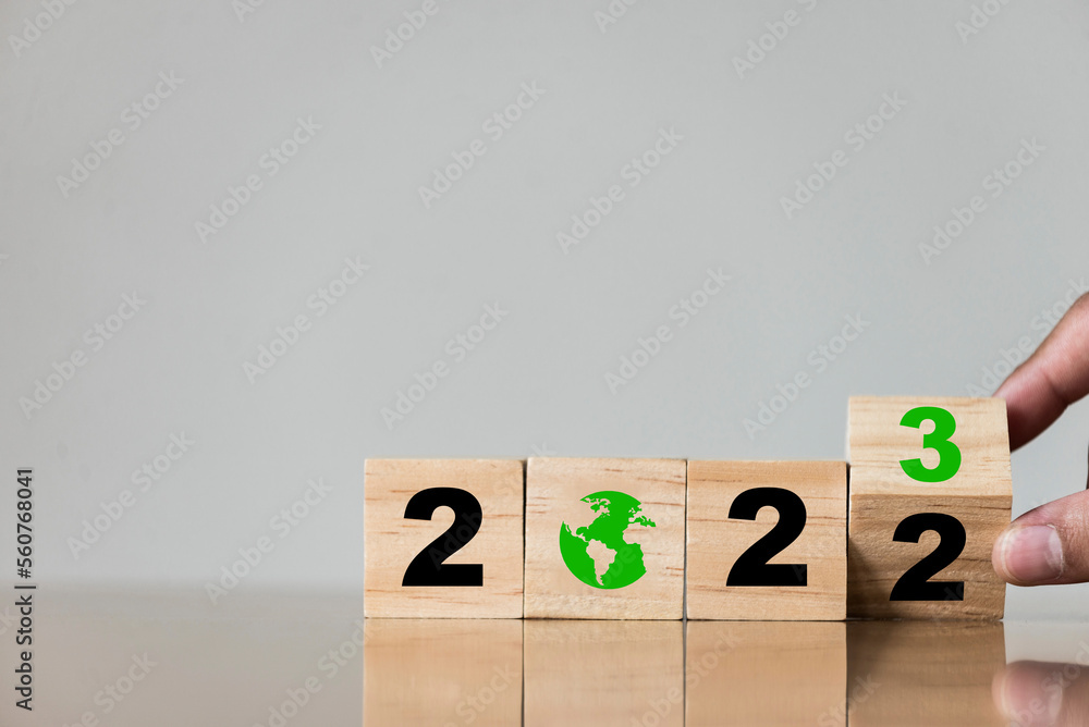 Wooden blocks with 2023 lettering and green globe icon. It shows that ...