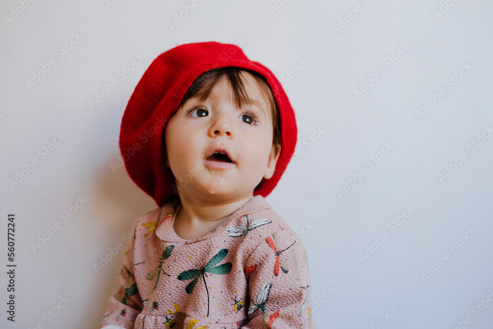 Cute baby girl drooling while looking up against wall at home Stock ...