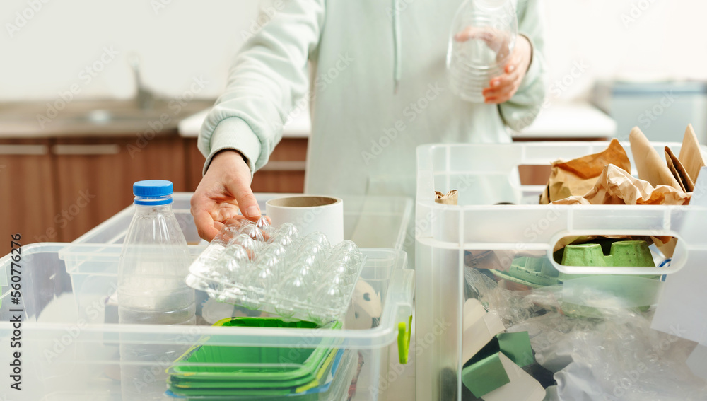 Sorting garbage for recycling. Teen girl is putting plastic package ...