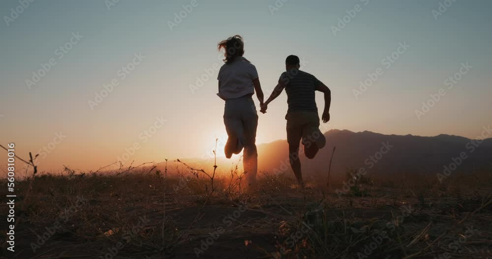 Video „Back view of love couple silhouette running into the sunset ...