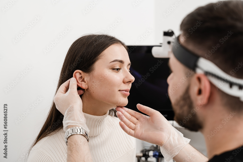 Otoplasty ear surgery. Surgeon doctor examines girl ears before ...