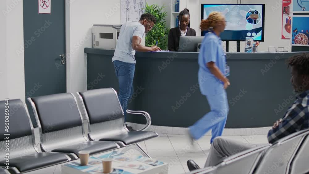 Young adult filling in checkup report papers at reception counter ...