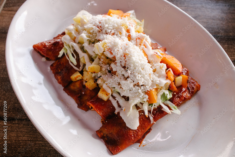 Enchiladas con lechuga, queso, crema, papa y zanahoria Stock Photo ...