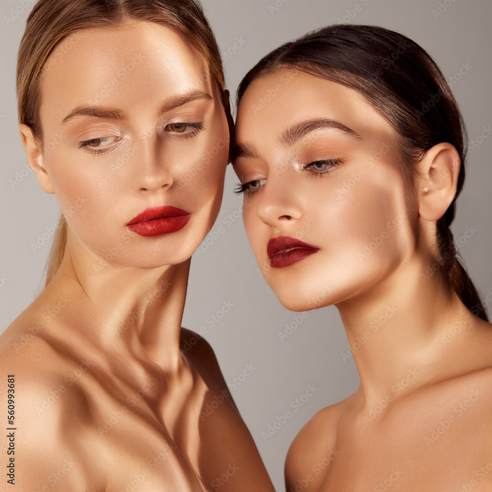 Aesthetics of beauty. Portrait of two young, beautiful girls with red ...