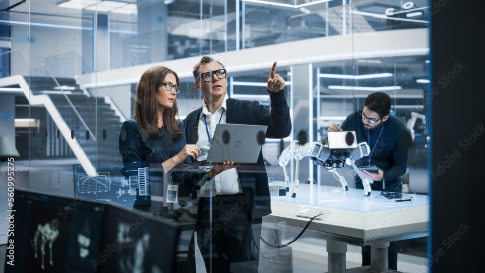 Portrait Of Two Young Female And Male Engineers Use Laptop Computer To Connect Analyze And