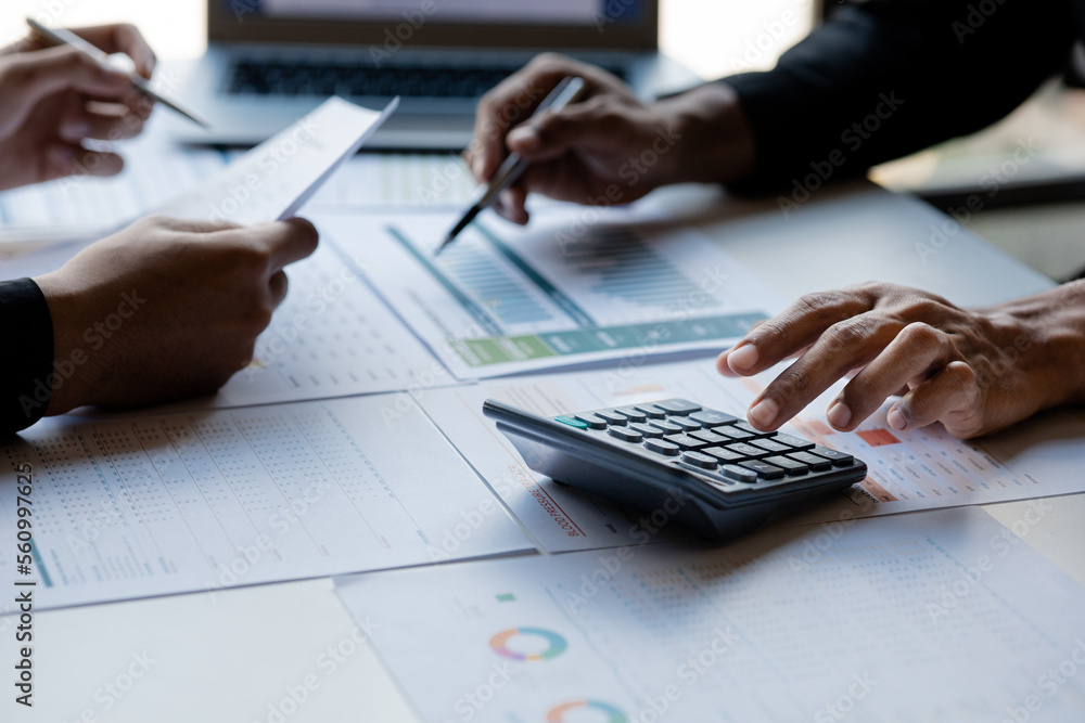 Businessman using a calculator to calculate numbers on a company's ...