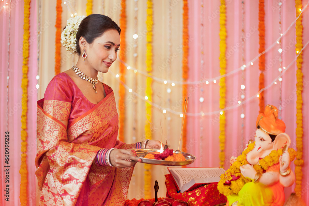 Happy Indian woman performing Ganesh aarti on Ganesh Chaturthi ...