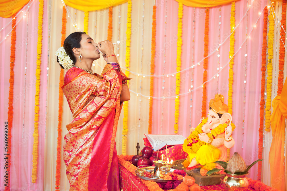 Image of an Indian woman in silk saree blowing shankh or a conch shell ...