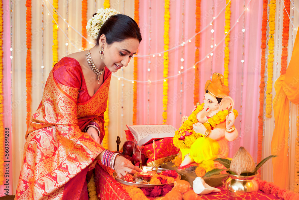 Portrait of a young happy woman doing Ganesh puja/pooja on Ganesh ...