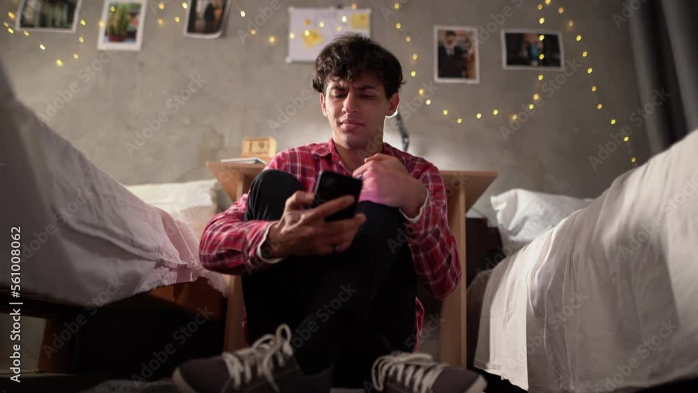 one sad teen student is holding a mobile phone while depressed sitting ...