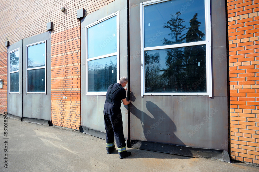 Fire territory station. Fireman opening the doors of a hangar with ...