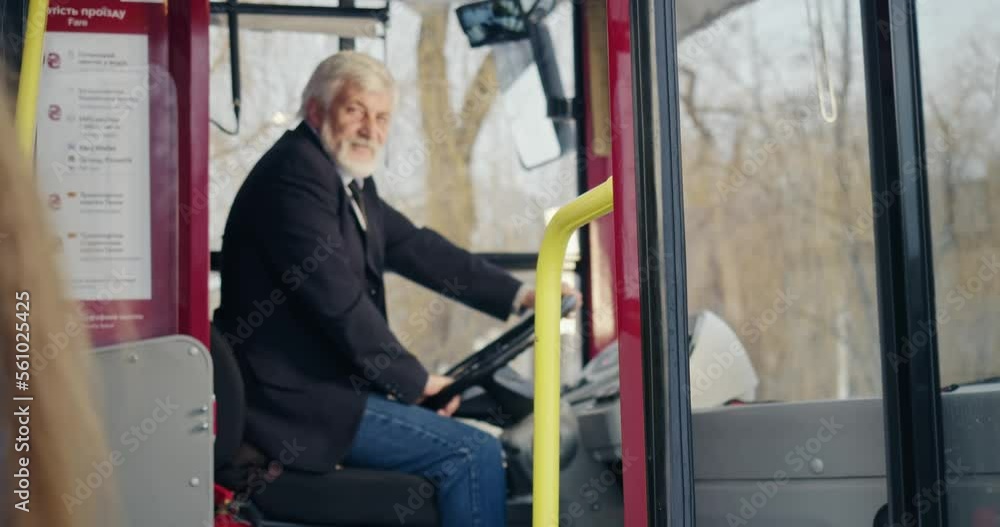 Side view of bus driver looking forward, passengers greeting. Old man ...