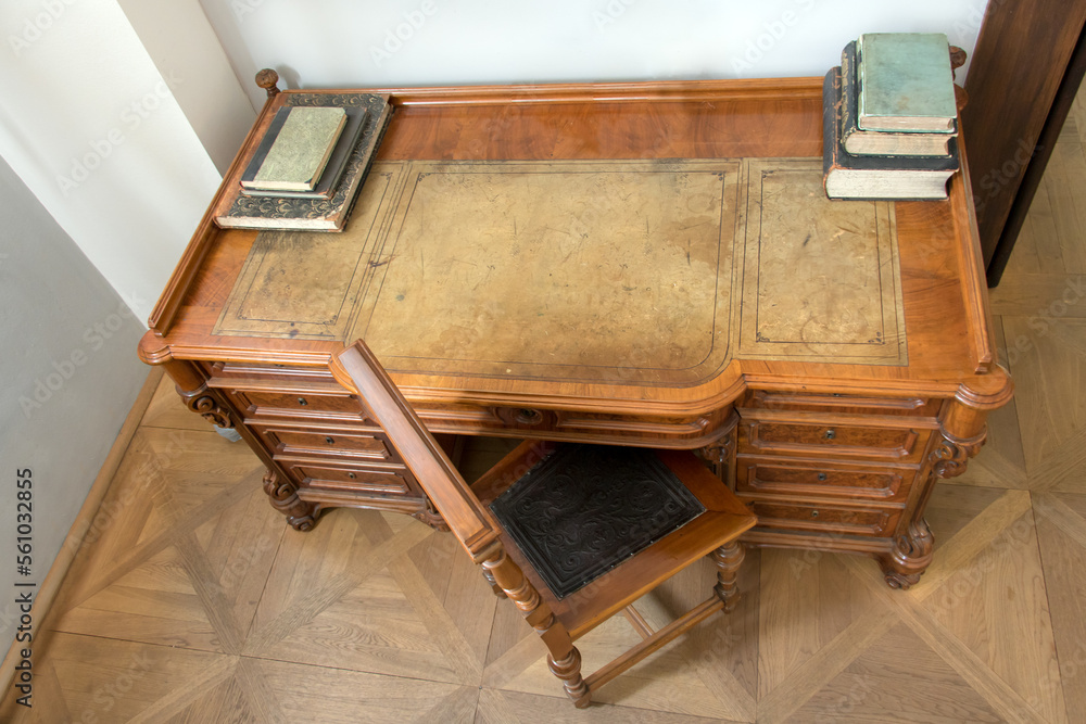 The old wooden table with seat, look from above. Historical office with ...