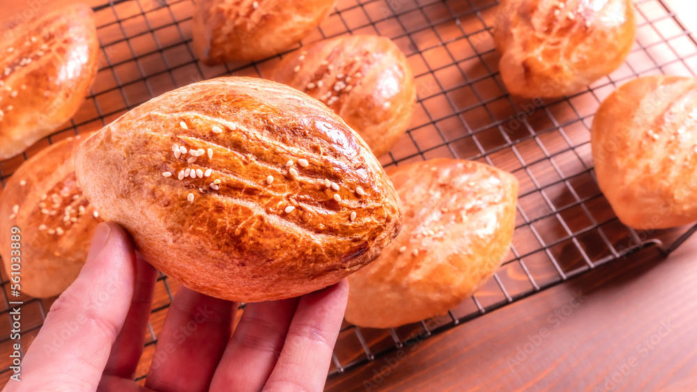 Soft pastry buns from Turkish cuisine, named pogaca. Male hand holding ...